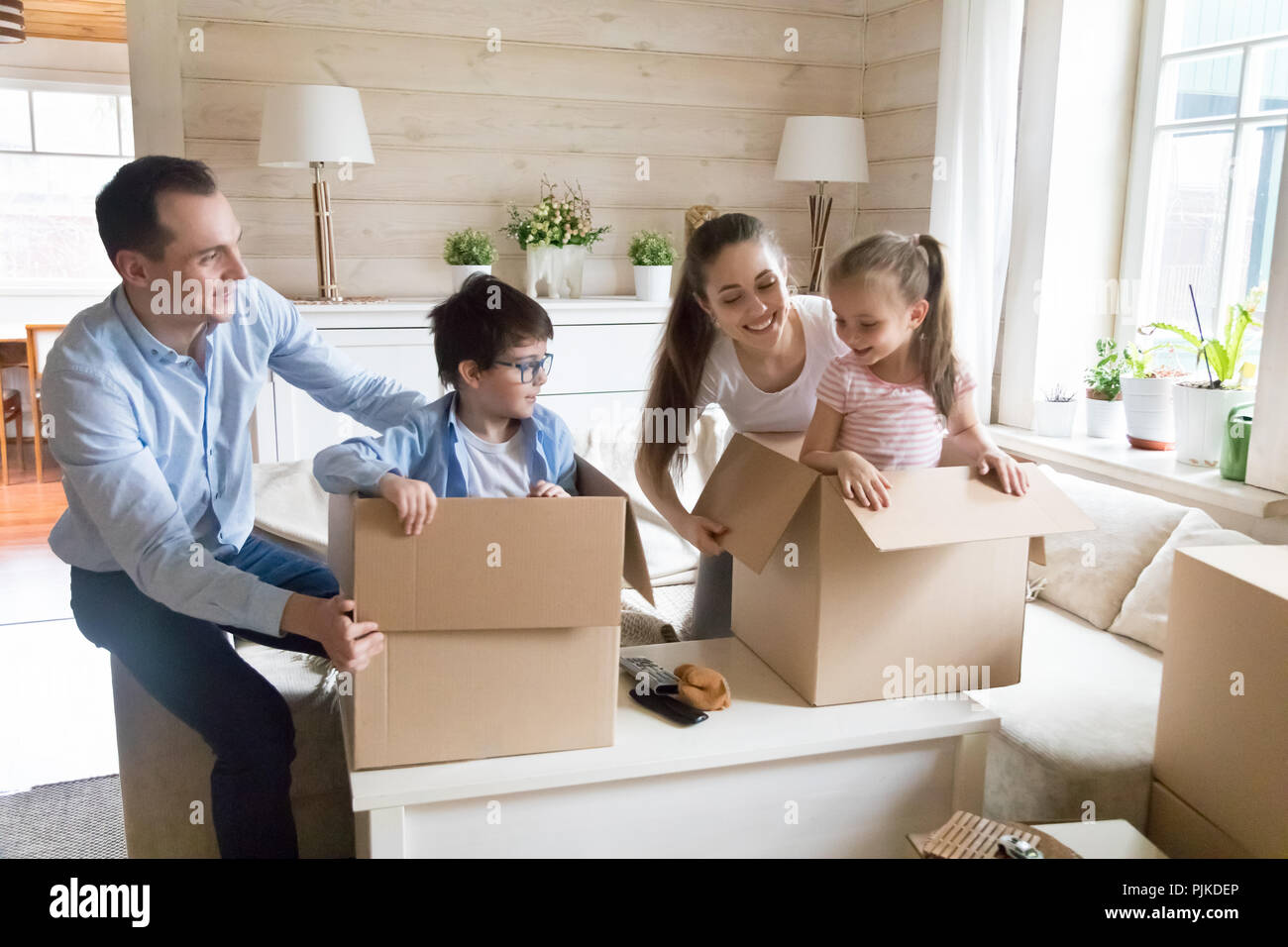 Cute kids hide in cardboard boxes playing during unpacking Stock Photo ...