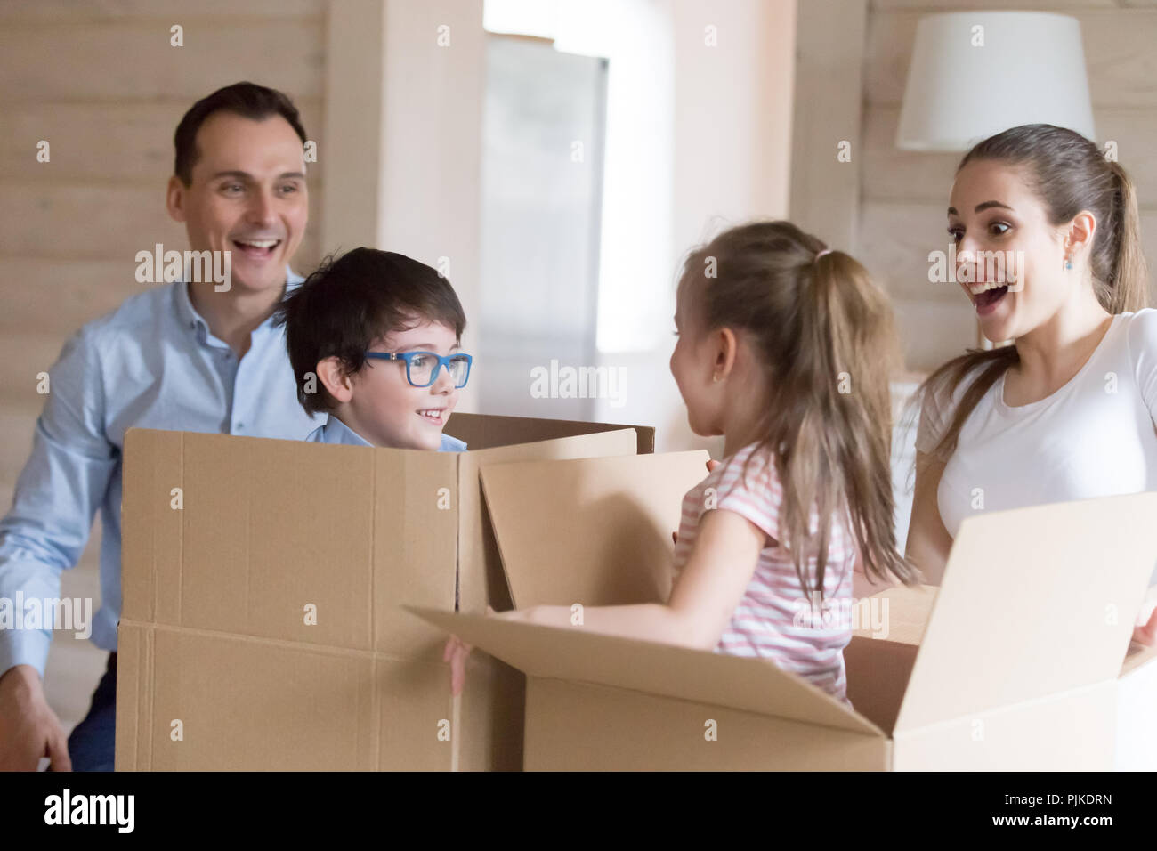Small kids jump out cardboard boxes playing with parents Stock Photo ...
