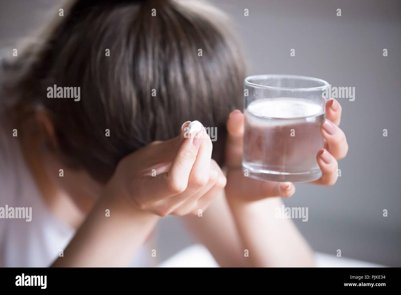 Woman suffering from pain having pill and water Stock Photo - Alamy