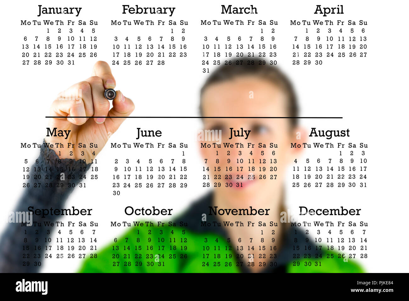 Virtual calendar on a transparent interface with a woman writing from ...