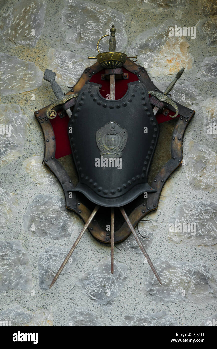 Ancient swords inside a knight armor, hanging on the stone wall Stock ...