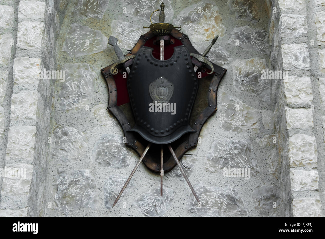 Ancient swords inside a knight armor, hanging on the stone wall Stock ...