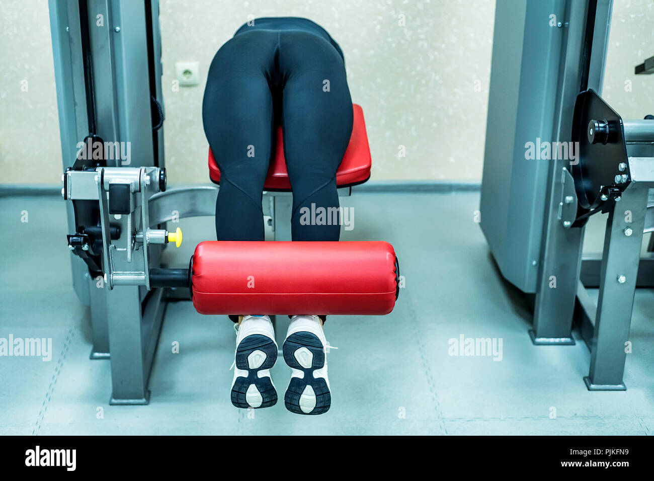 Young woman does leg exercises in gym lying Stock Photo - Alamy