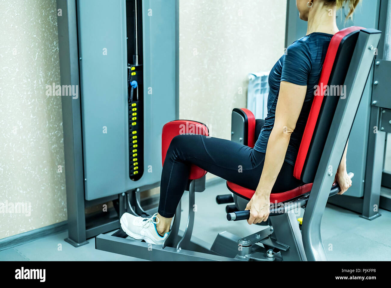 Side view young woman does leg exercises in gym Stock Photo - Alamy