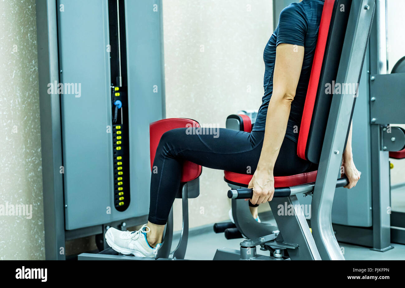 Side view young woman does leg exercises in gym Stock Photo - Alamy