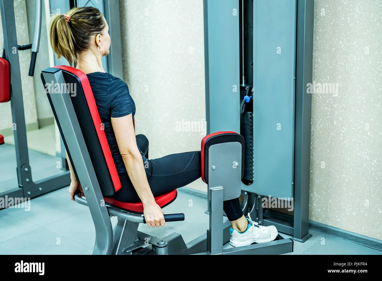 Side view young woman does leg exercises in gym Stock Photo - Alamy