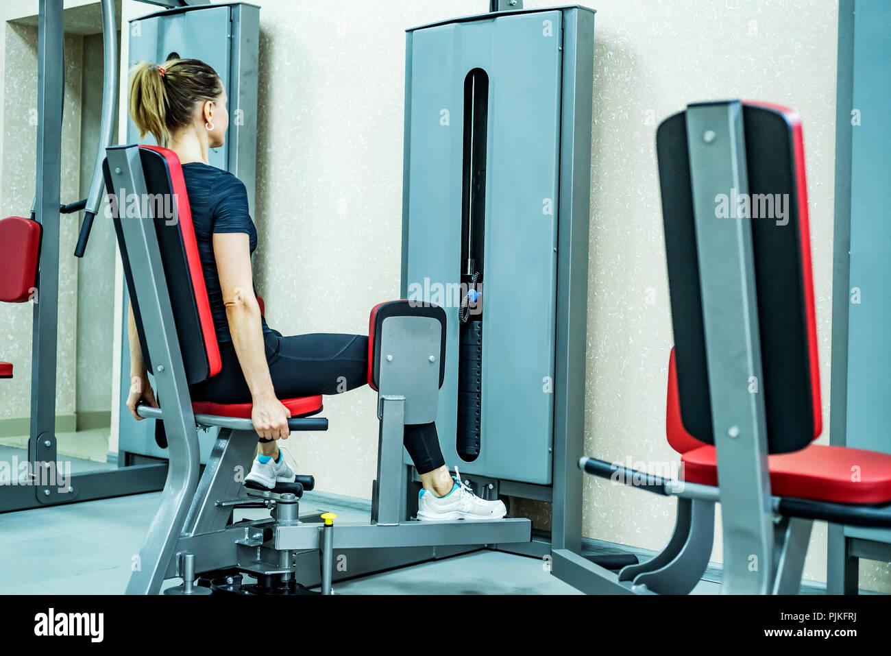Side view young woman does leg exercises in gym Stock Photo - Alamy