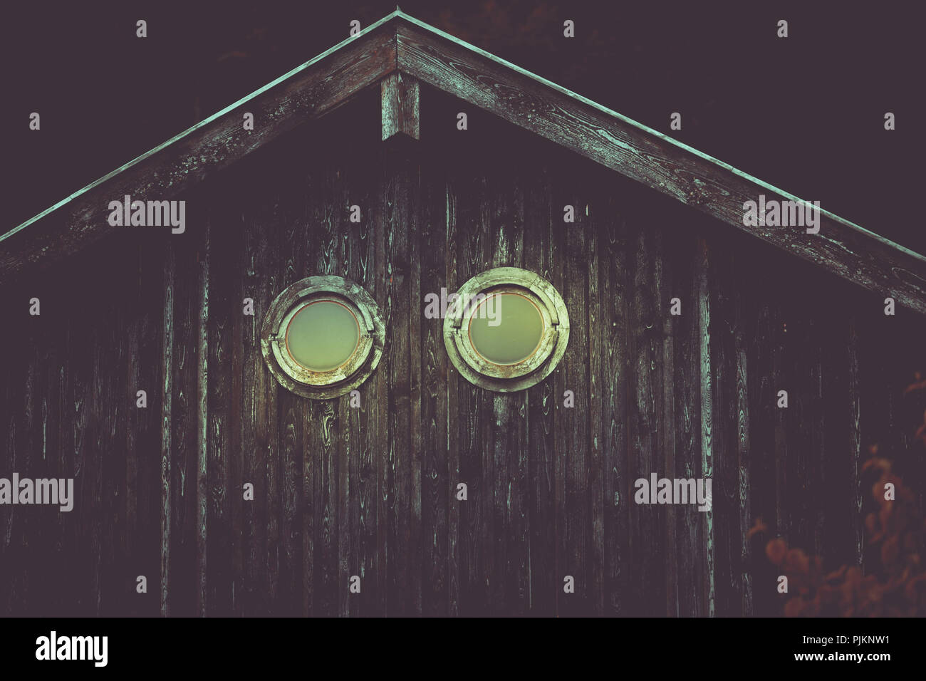 A rustic wooden hut with round window openings Stock Photo - Alamy