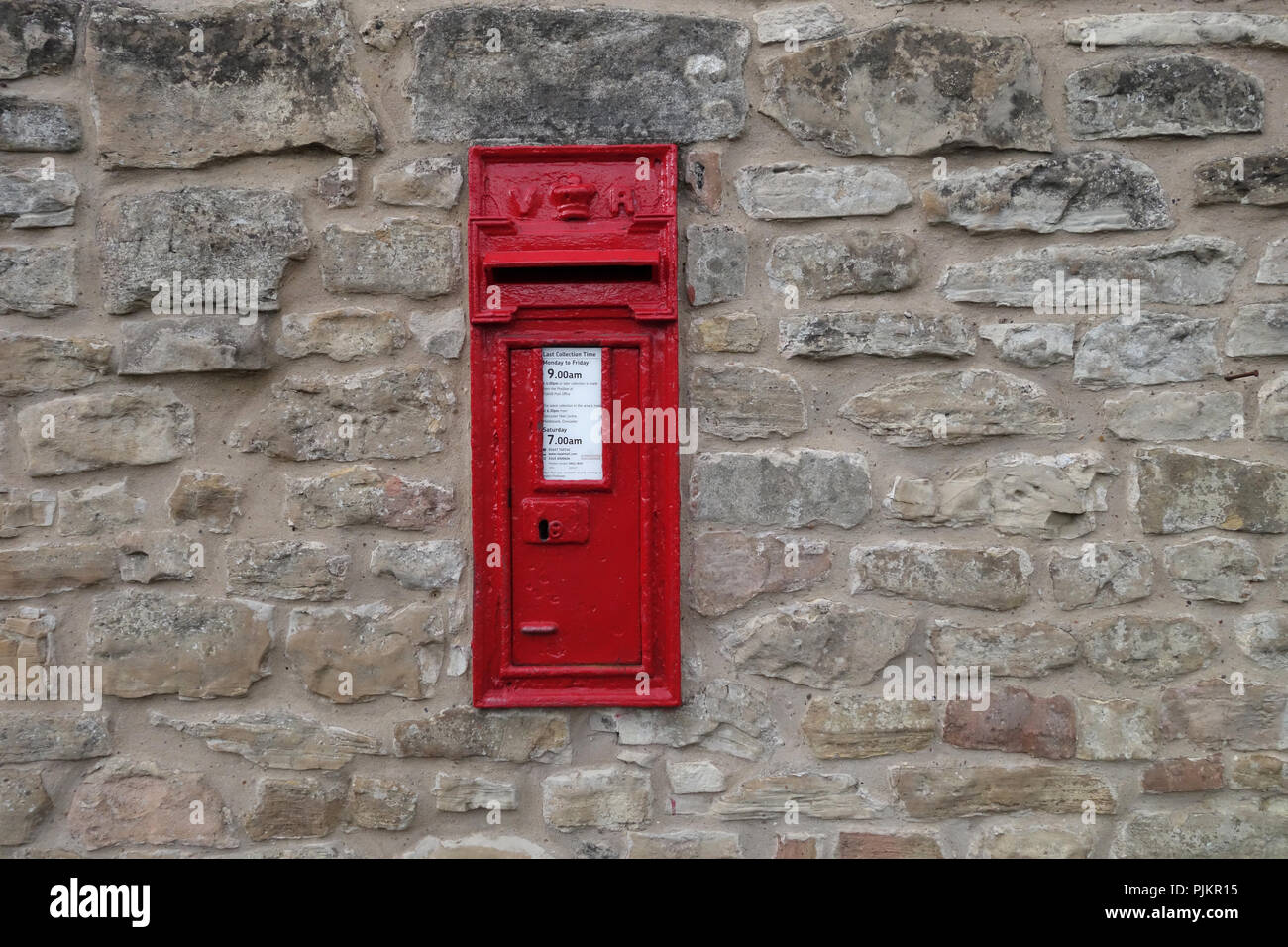 English village post box built into large stone wall Stock Photo - Alamy