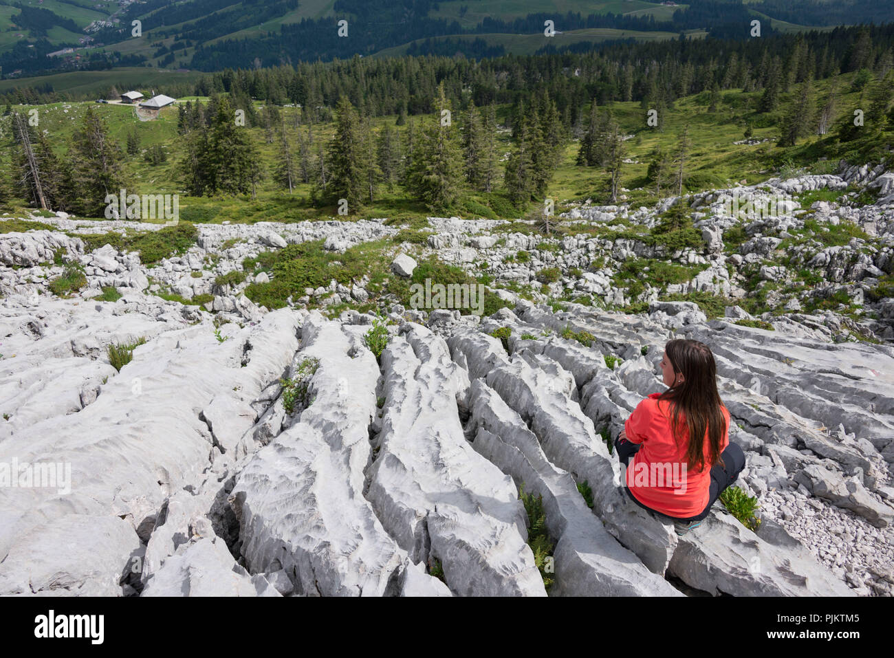 Woman hiking in the karst field Schrattenfluh, landscape in the ...