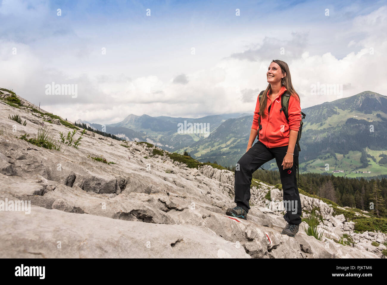 Woman hiking in the karst field Schrattenfluh, landscape in the ...