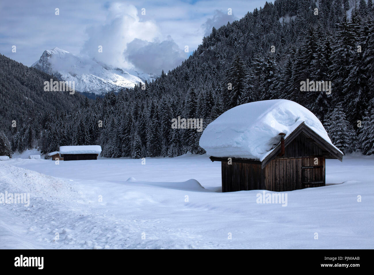 Alpine winter landscape with wooden huts Stock Photo - Alamy