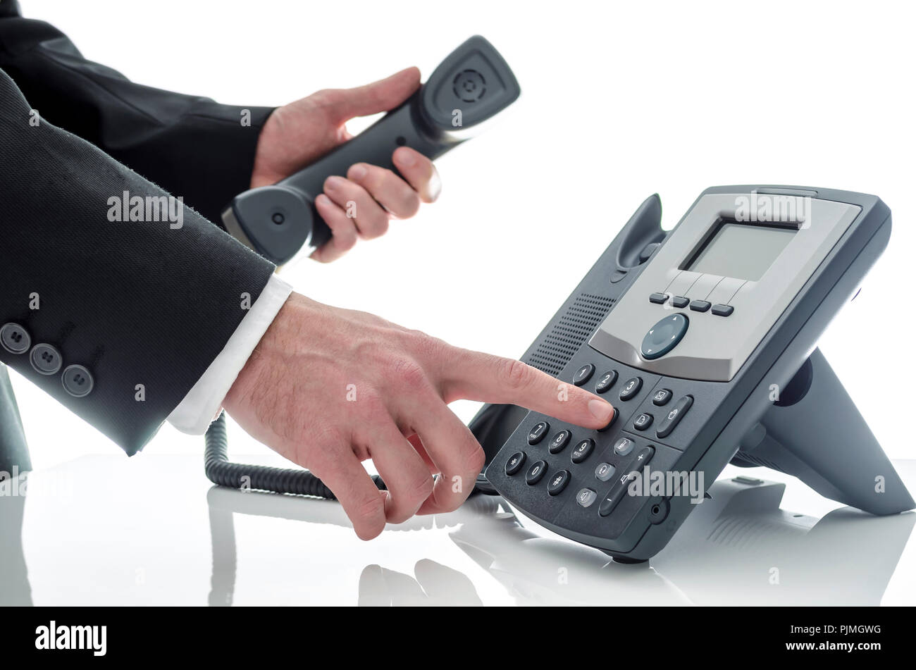 Male hand dialing number on a black phone against a white background ...