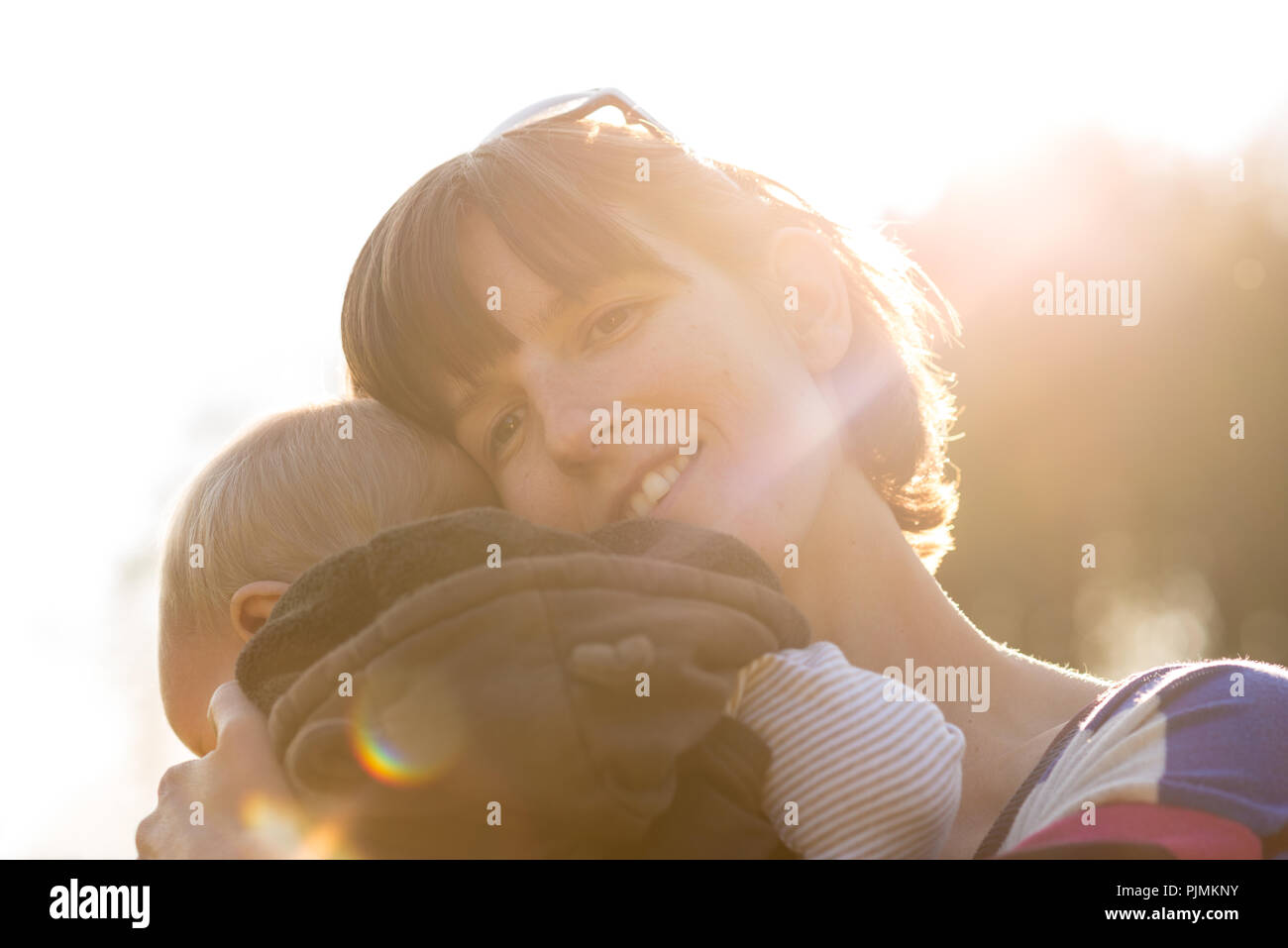 Happy loving protective mother cuddling her young infant to her ...