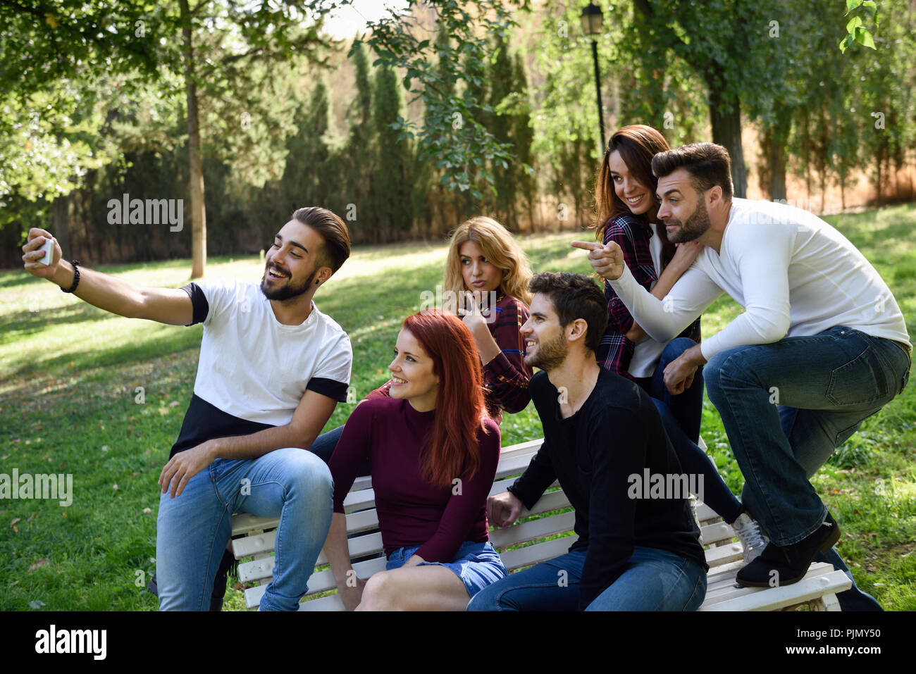 Group of friends taking selfie in urban park. Five young people wearing ...