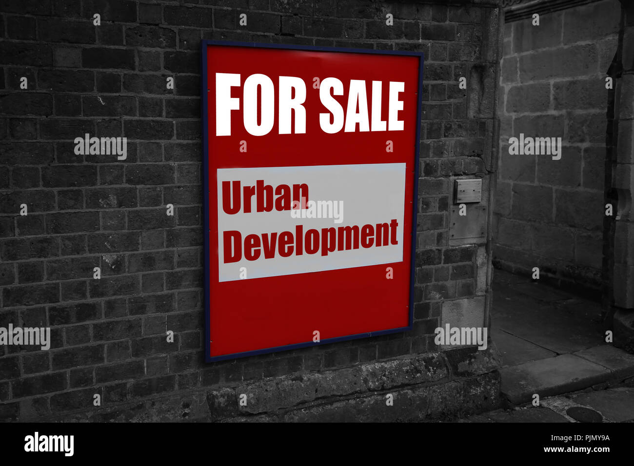 For sale with urban development written on a sign attached to a brick ...