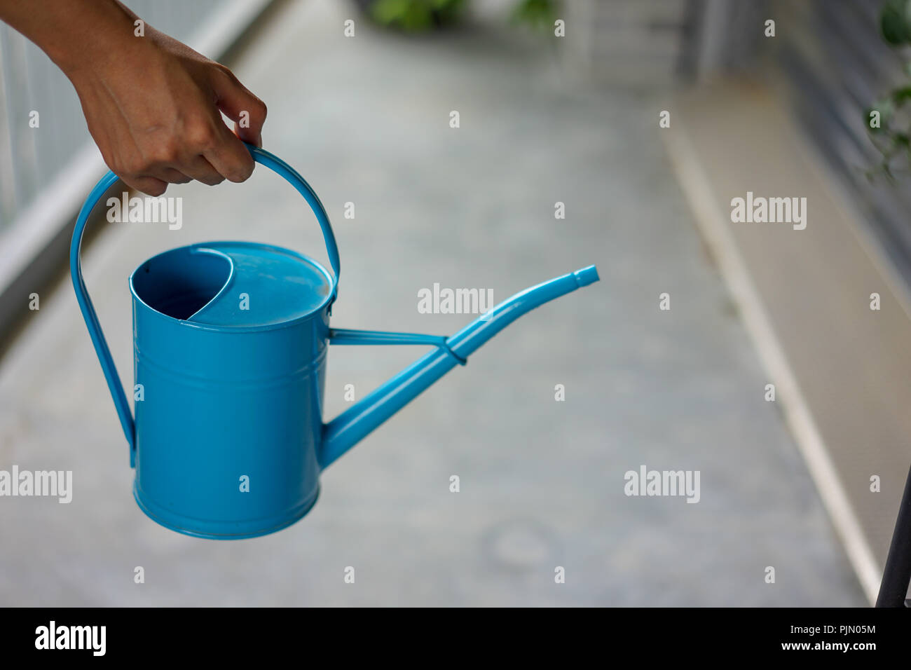 home gardening concept photo with hand holding water can Stock Photo ...