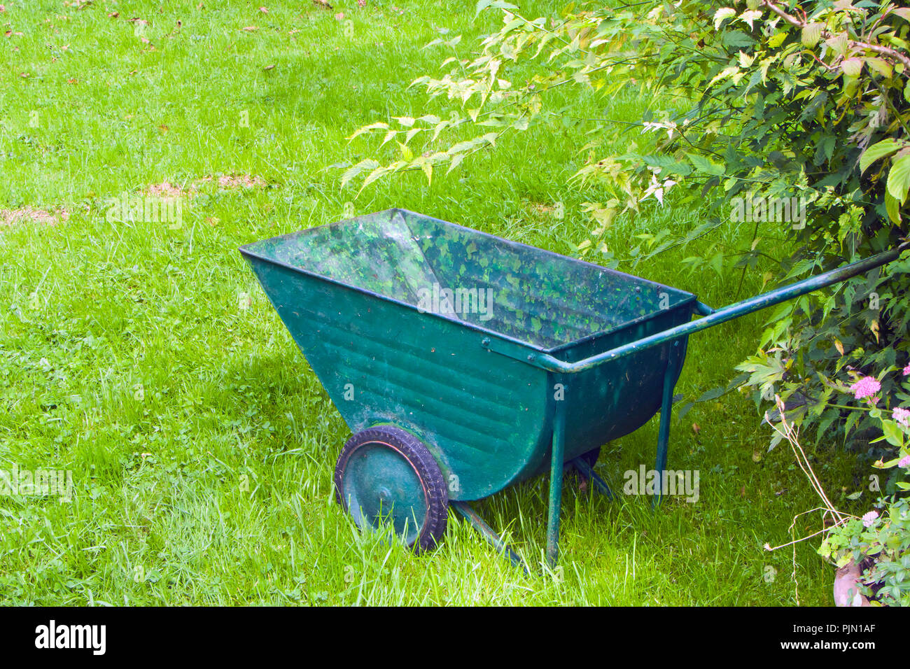 An image of an old green wheelbarrow Stock Photo - Alamy