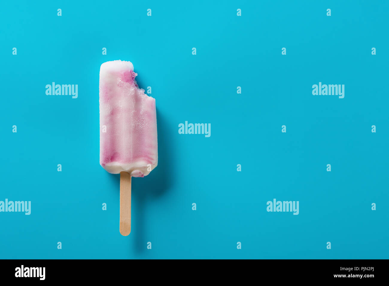 strawberry flavor popsicle with a bite on a blue background Stock Photo ...