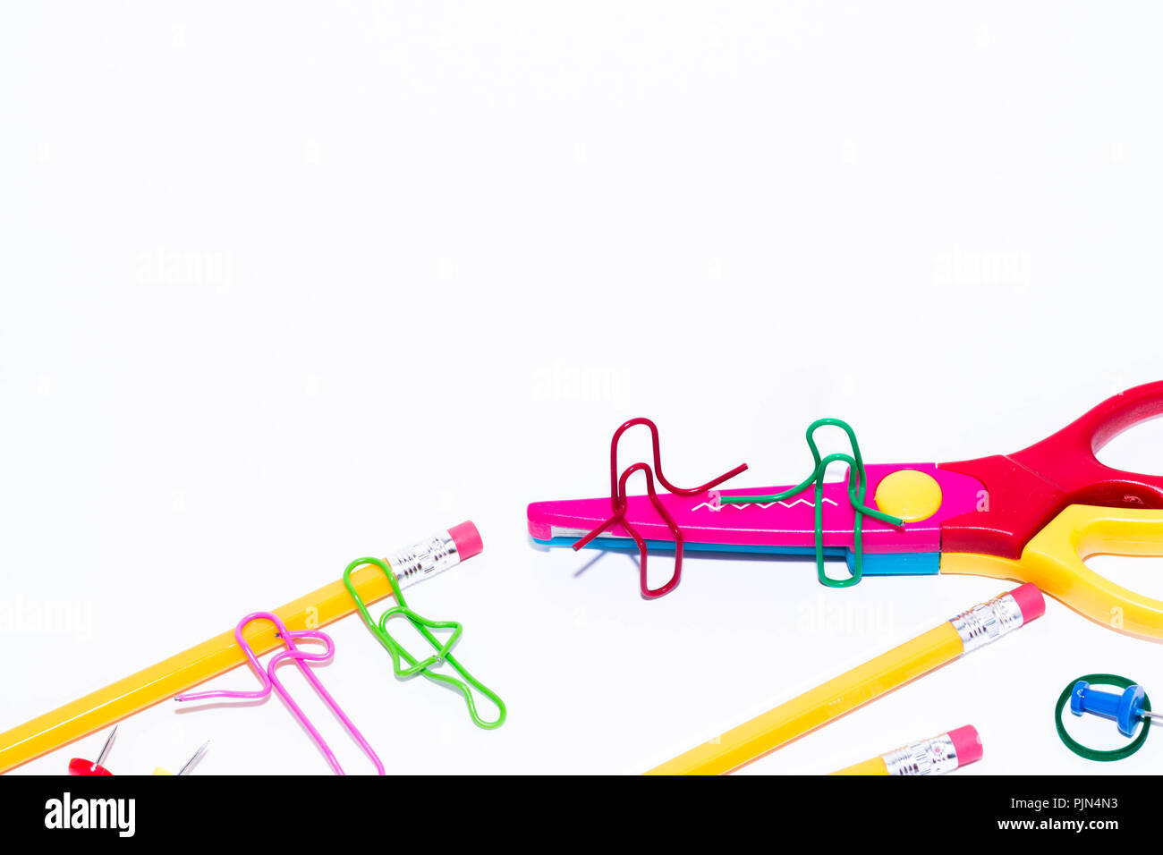 Two paper clips talking, sitting on a zigzag scissors and two lying and ...