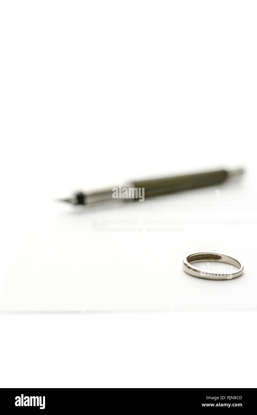 Wedding ring and ink pen on divorce papers Stock Photo - Alamy