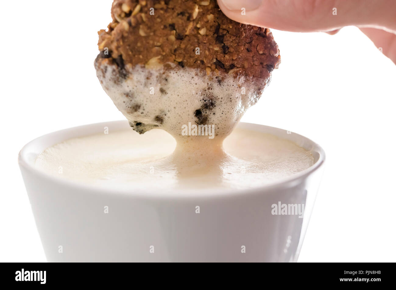Closeup of a hand dipping a cookie in cocoa. Isolated over white ...