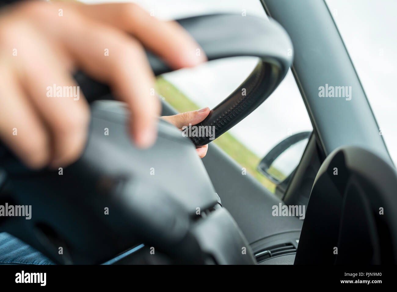 Detail of hands holding wheel of a car Stock Photo - Alamy