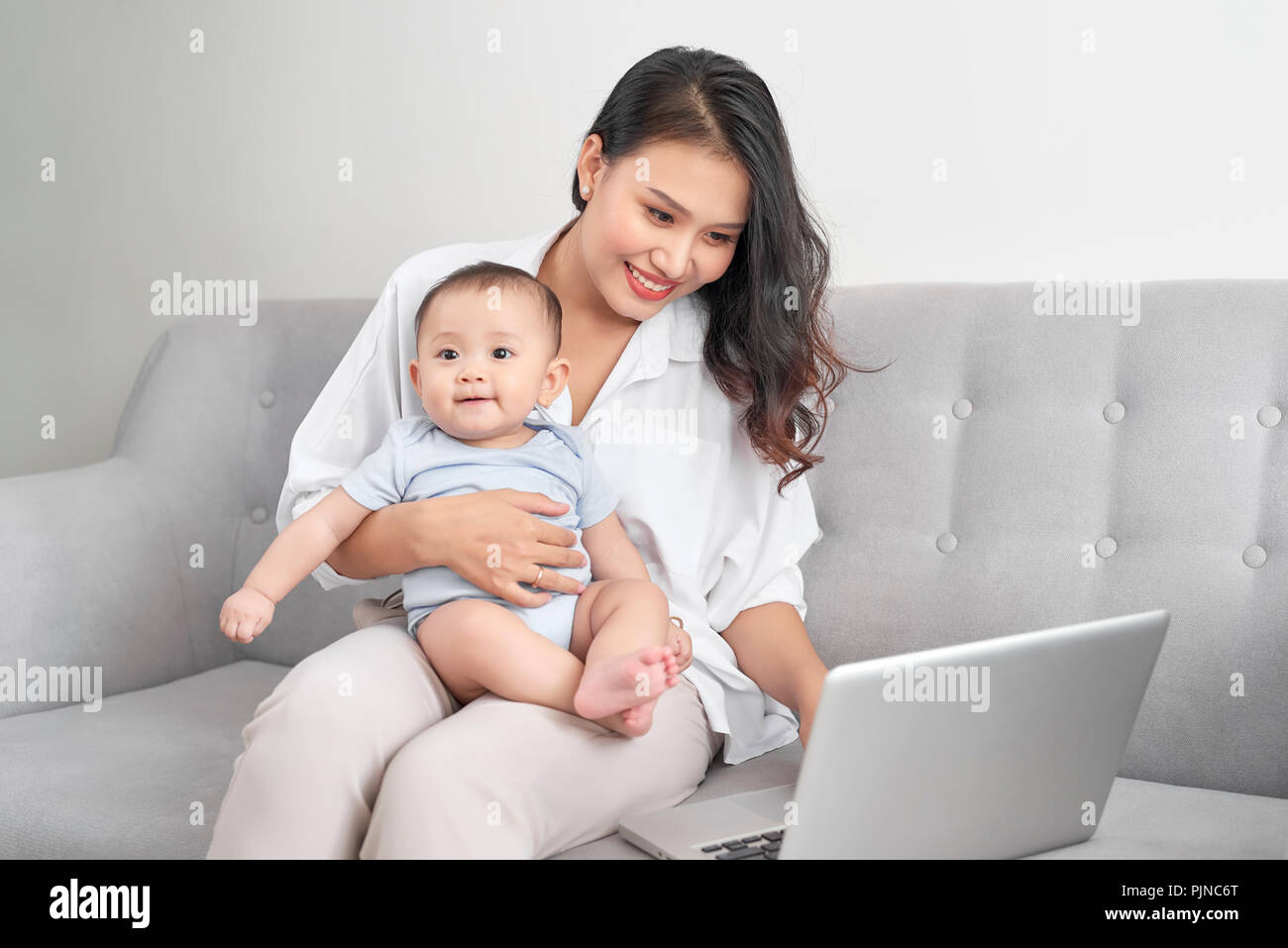 Happy family mother and baby at home using laptop computer Stock Photo ...