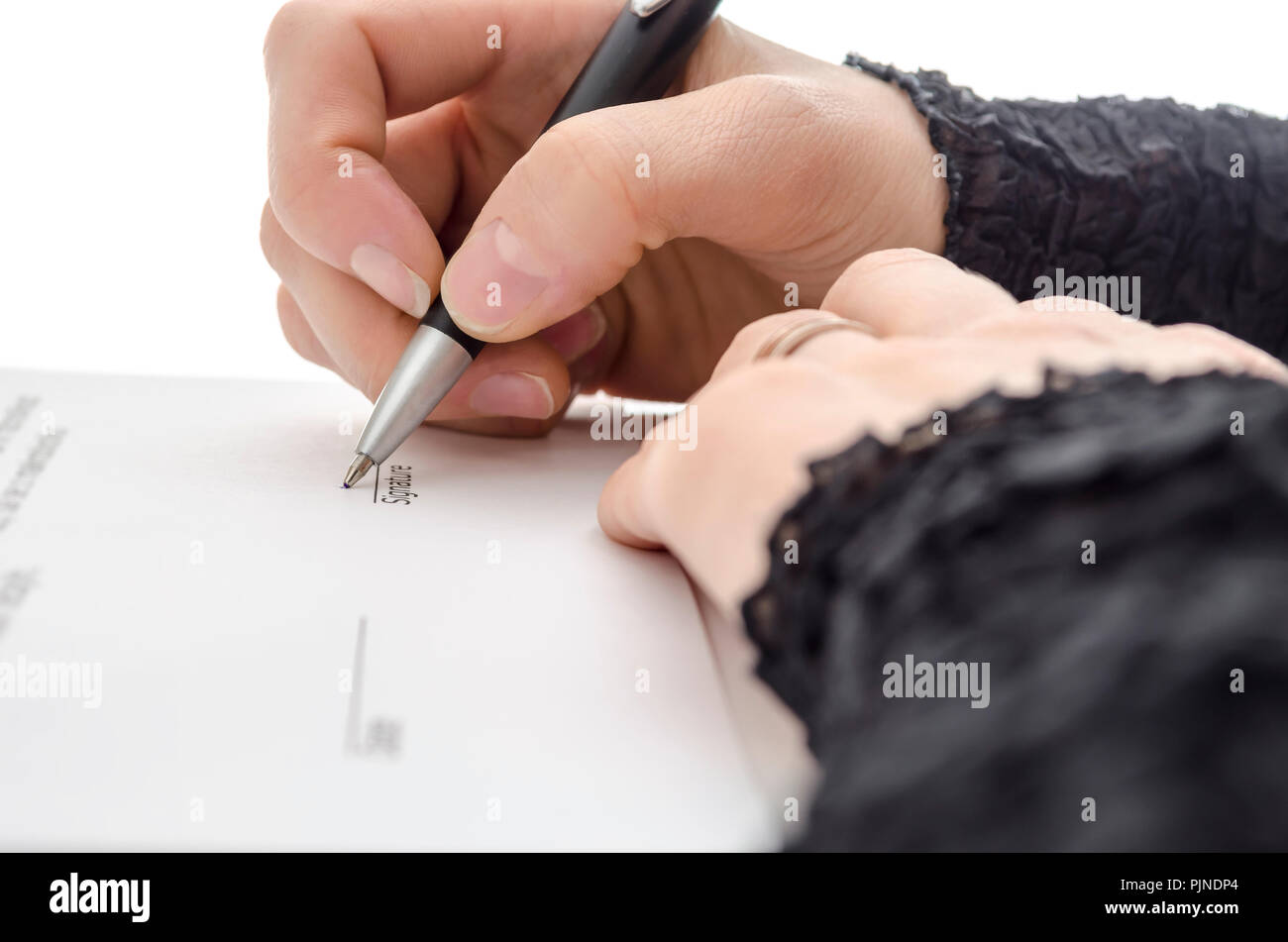 Closeup of a businesswoman signing a contract above signature line ...