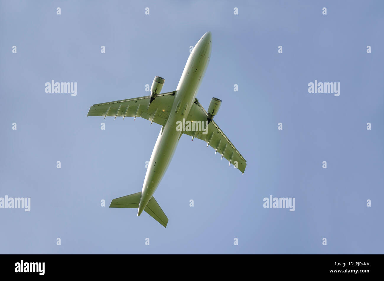 Bottom view of airplane taking off on a clear blue sky Stock Photo - Alamy