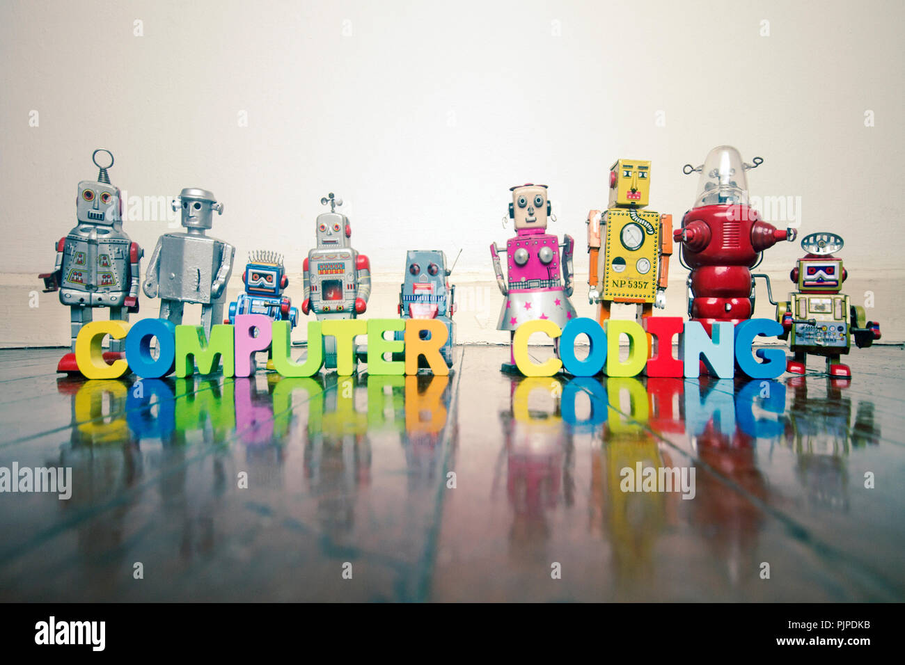COMPUTER CODING wooden letters and retro robot toys on a wooden floor ...