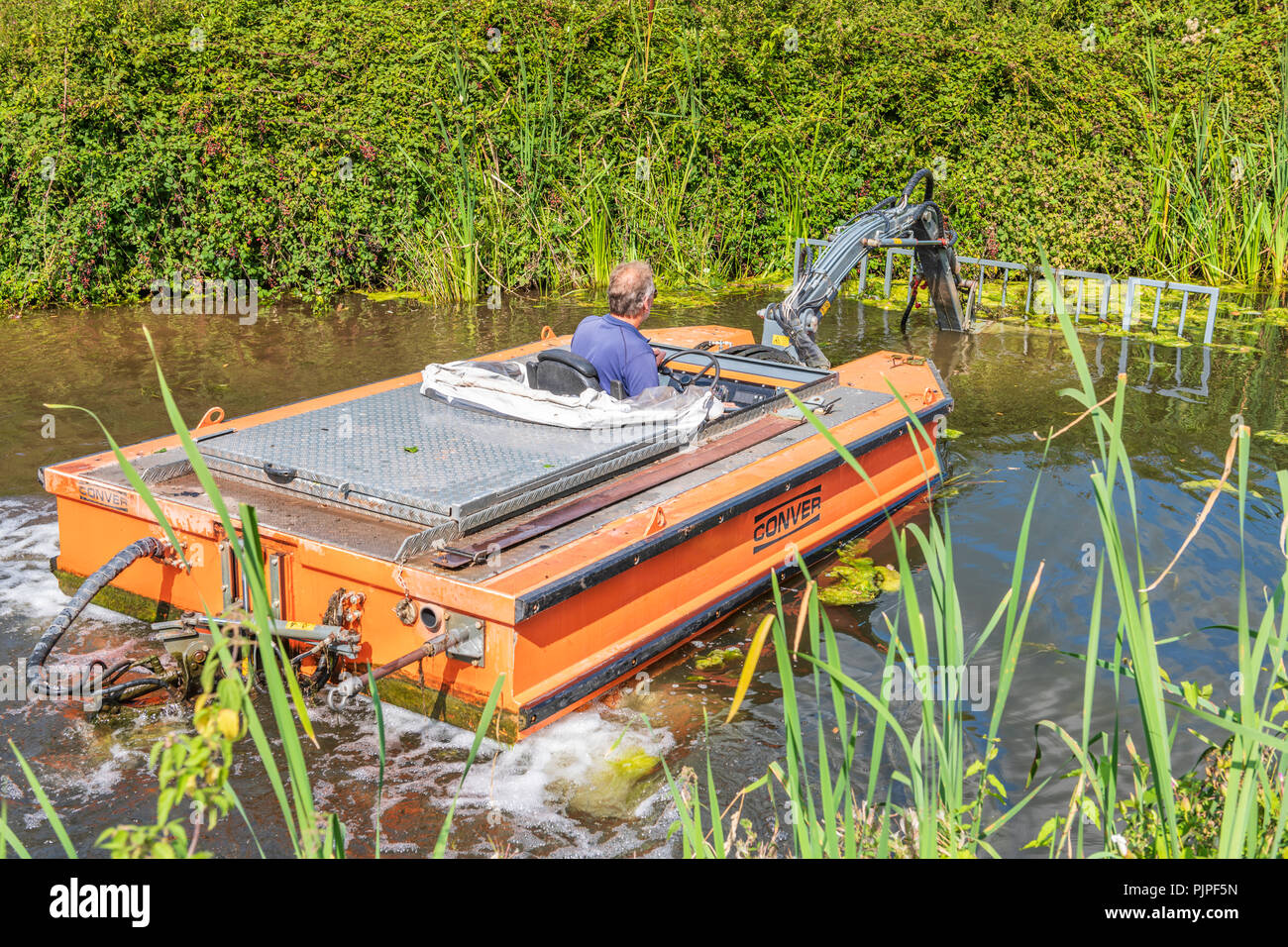 A small dredger is used to clear summer weed growth on the Grand ...