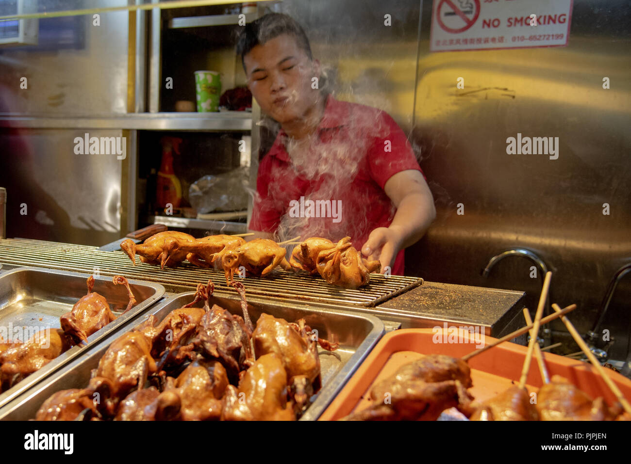Beijing, China – June 1 2018: Chef in his red uniform cooking ...