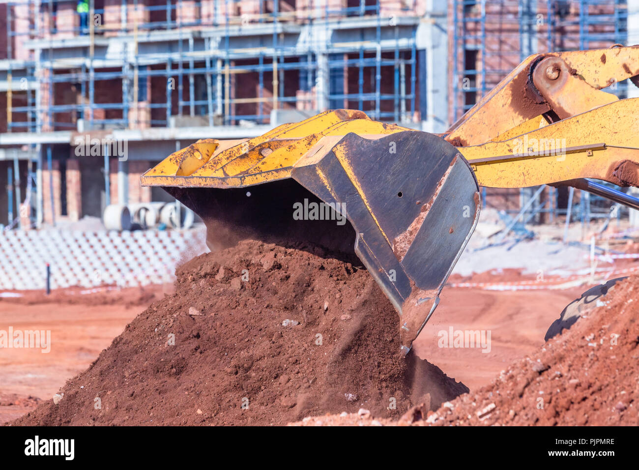 Construction earthworks grader machine bucket tipping earth closeup ...