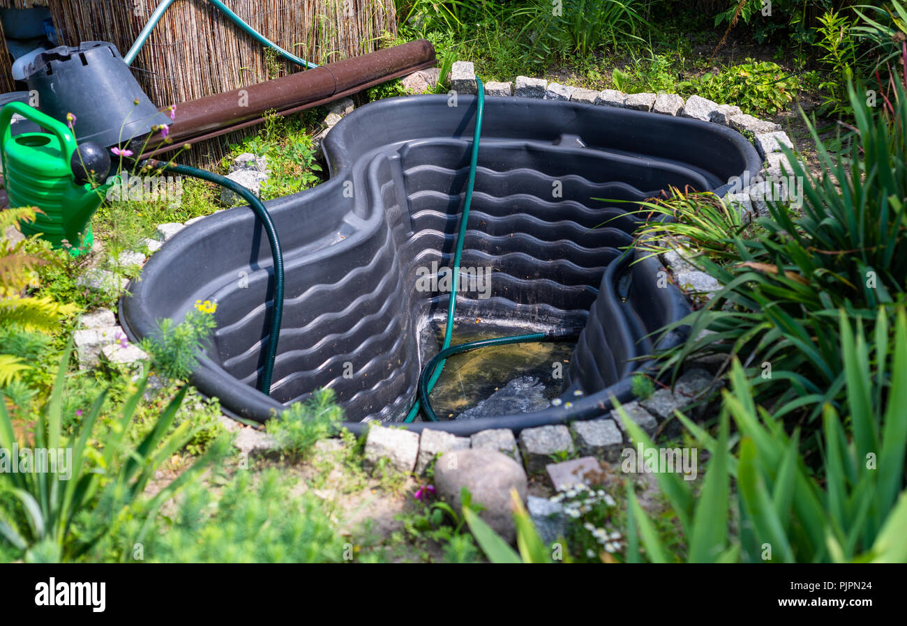 Empty, plastic garden water tank dug into the grounds in the background ...