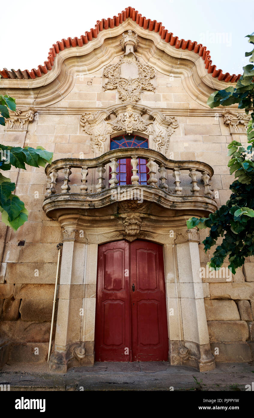 Detail of the portal, balcony with balusters and unfinished coat of ...