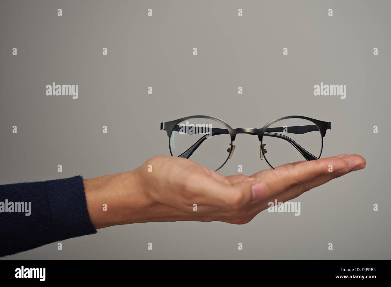 Holding glasses on hand palm close-up isolated on gray background Stock ...
