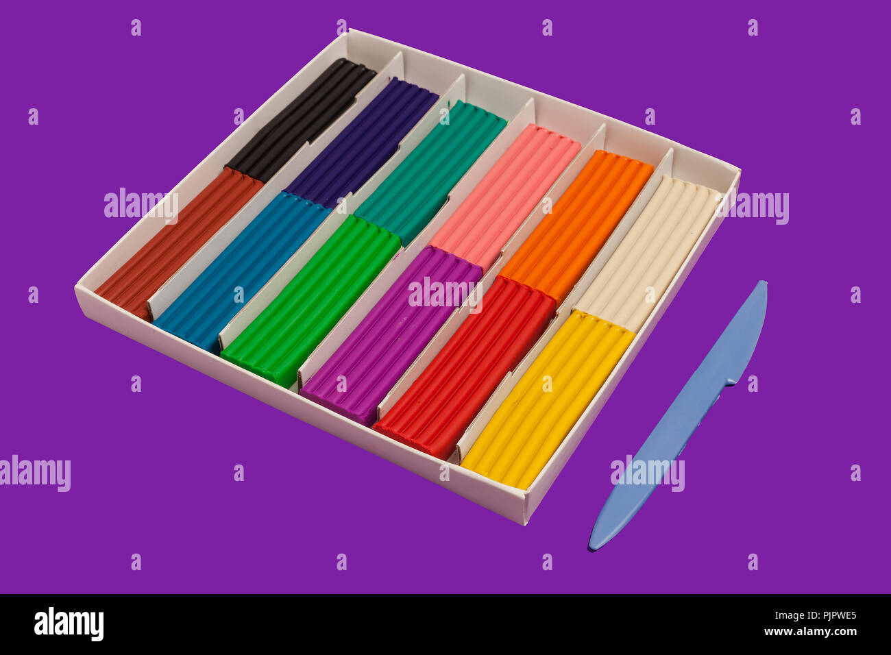 Set of colorful plasticine sticks lying in a box near a plastic knife ...