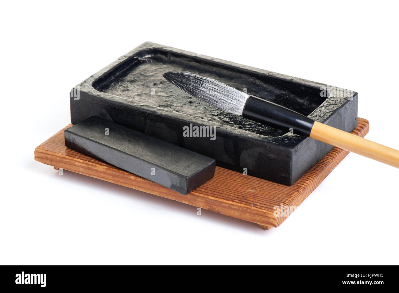 inkstone, inkstick and traditional writing brush isolated on white ...