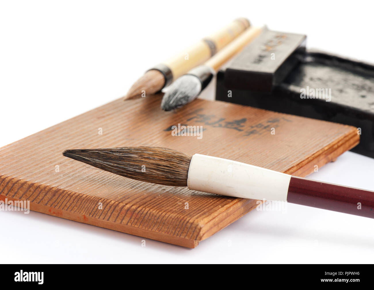 inkstone, inkstick and traditional writing brush isolated on white ...