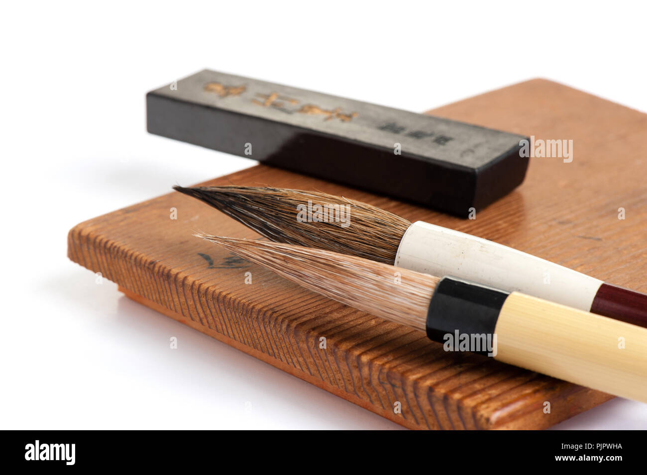 inkstone, inkstick and traditional writing brush isolated on white ...