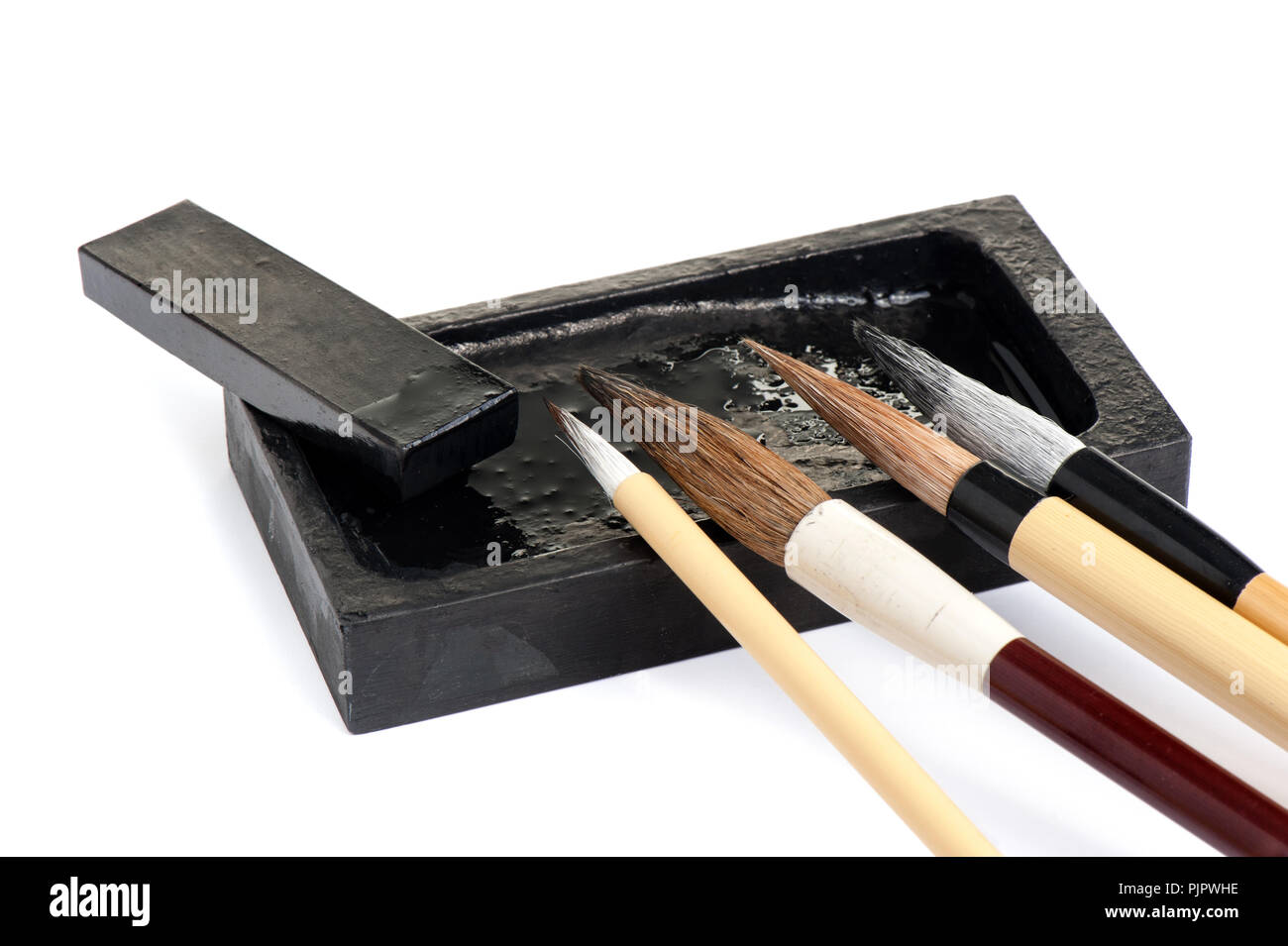 inkstone, inkstick and traditional writing brush isolated on white ...