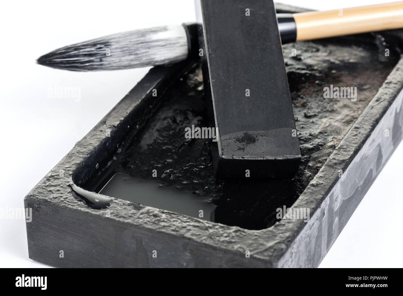 inkstone, inkstick and traditional writing brush isolated on white ...