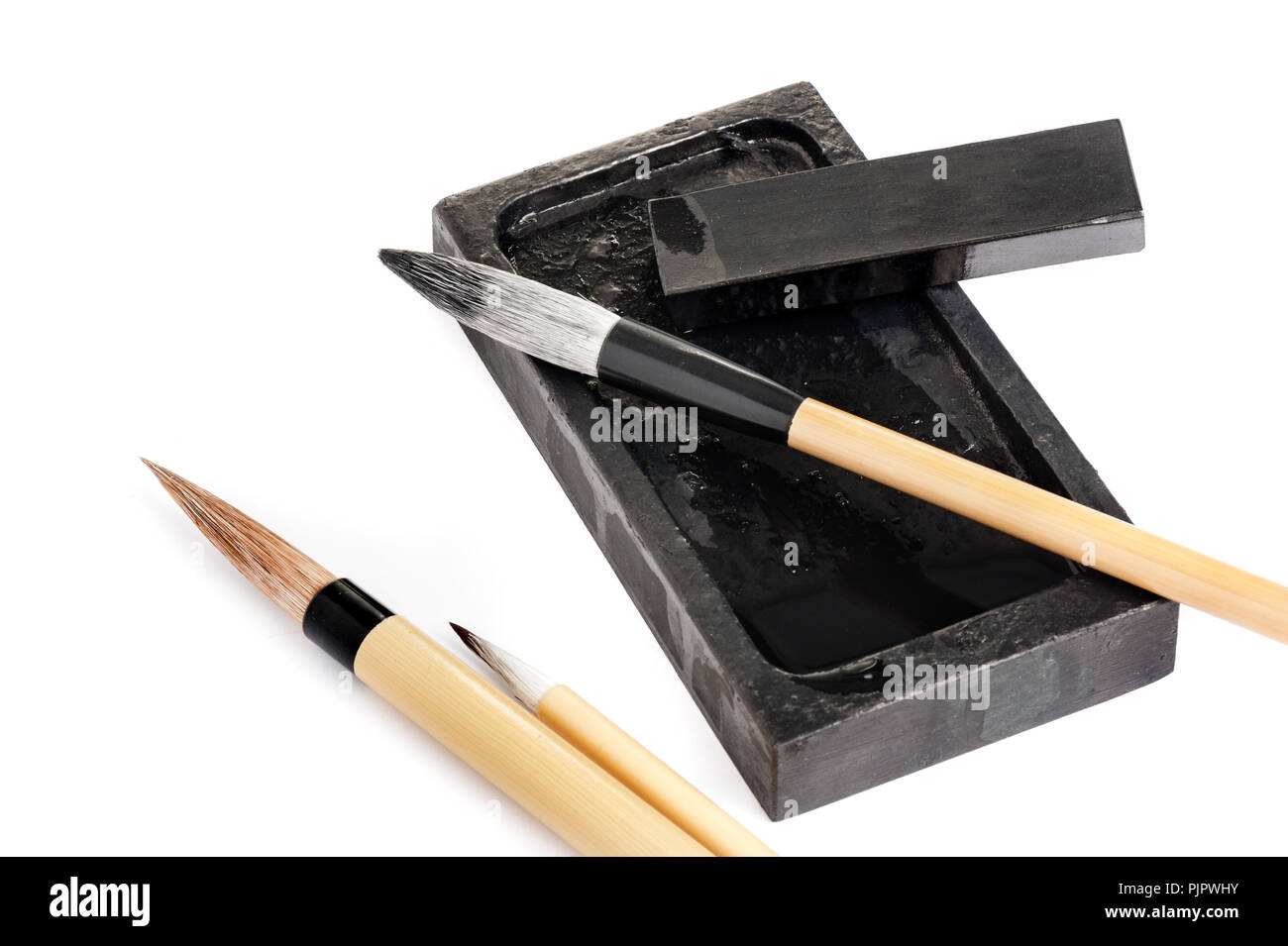 inkstone, inkstick and traditional writing brush isolated on white ...