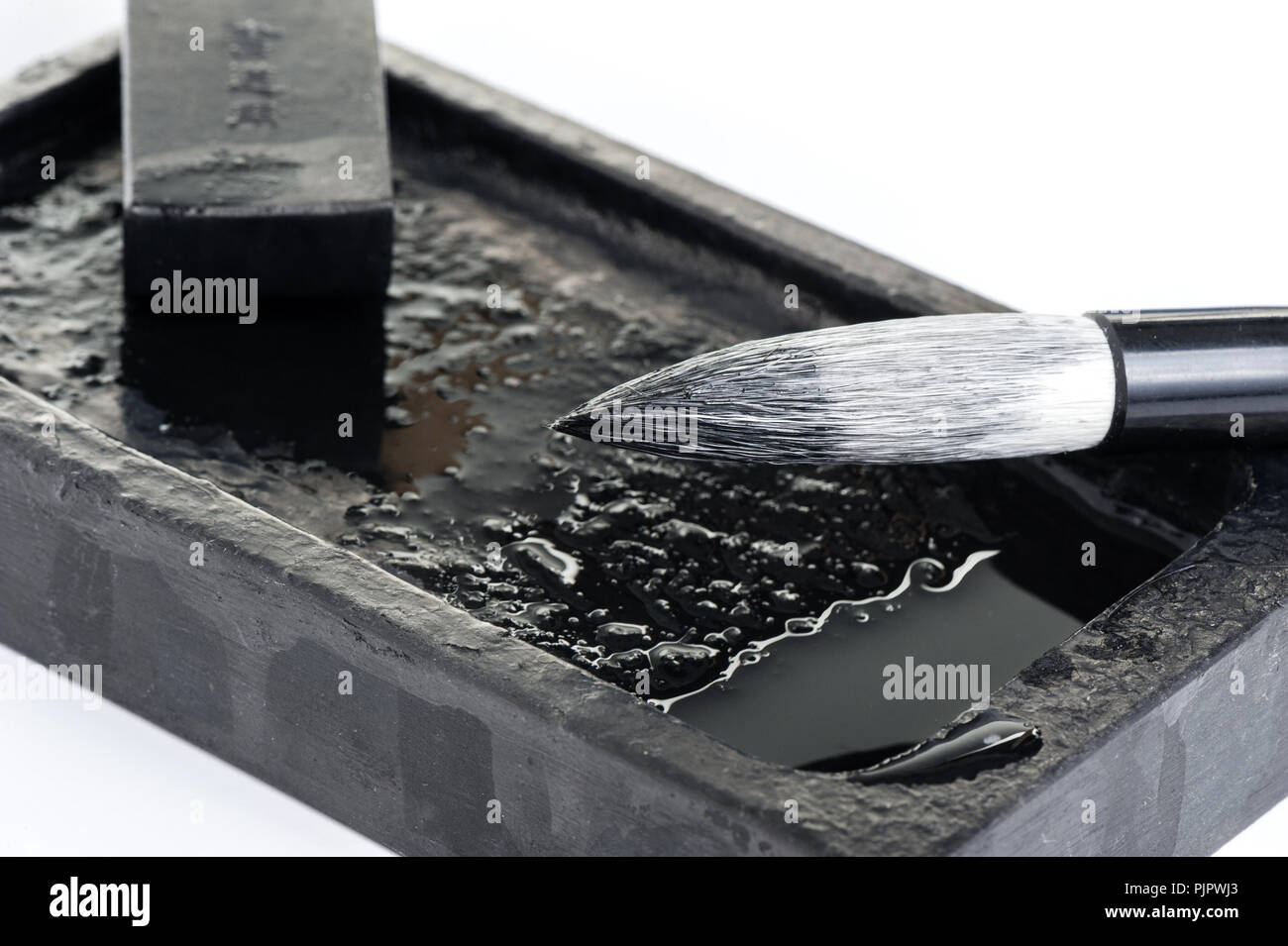 inkstone, inkstick and traditional writing brush isolated on white ...