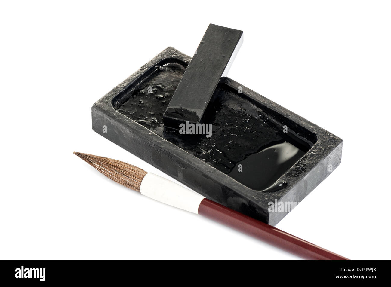 inkstone, inkstick and traditional writing brush isolated on white ...