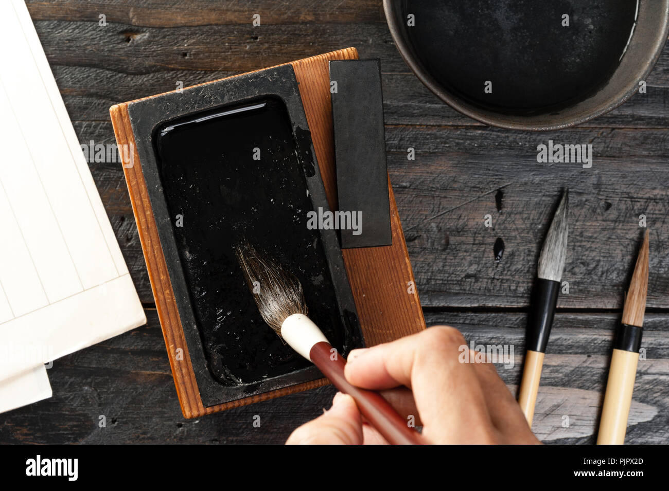 inkstone and brush, closeup man's hand using brush and traditional ...