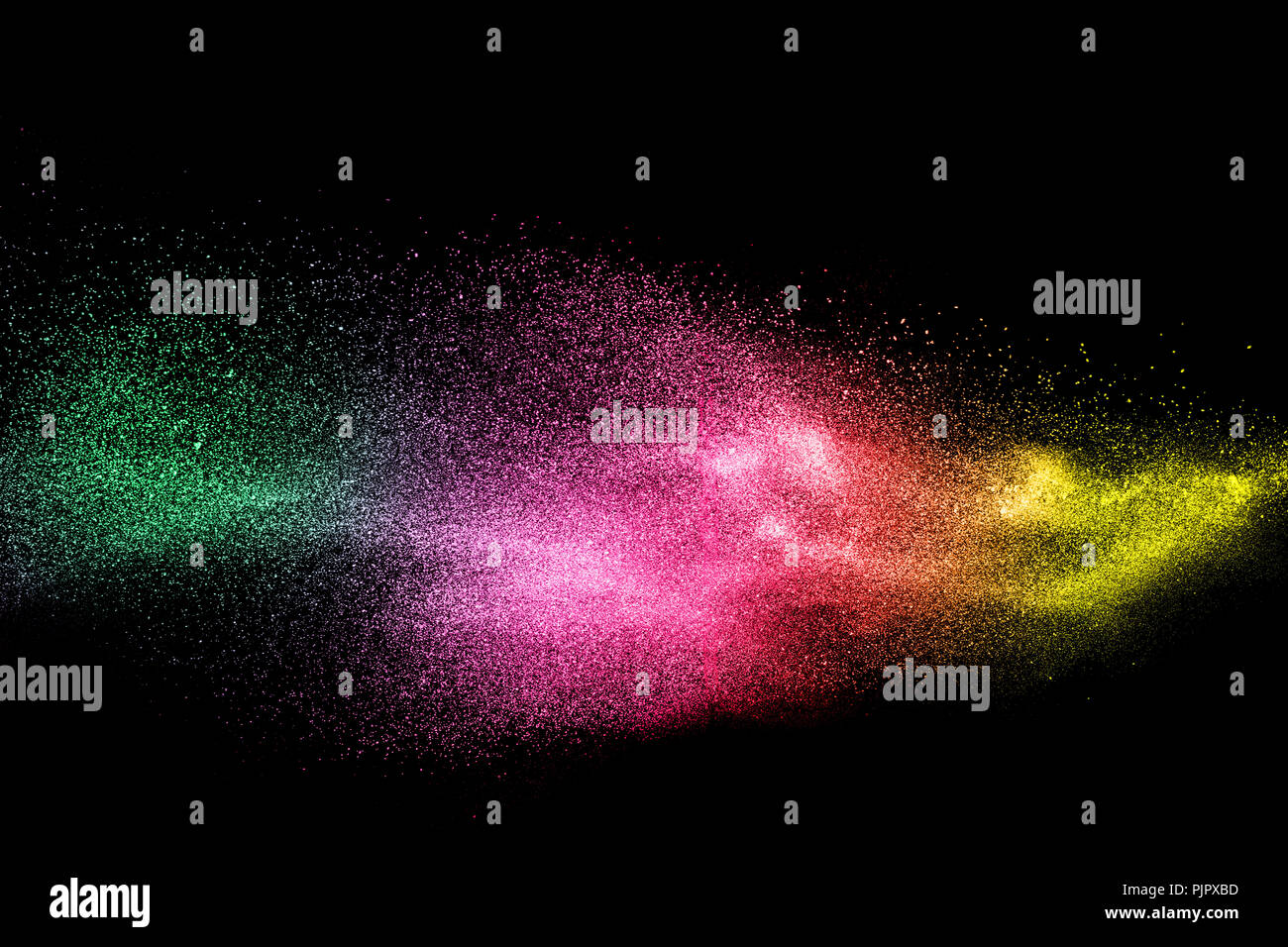 Green pink and yellow dust particles explosion on black background ...