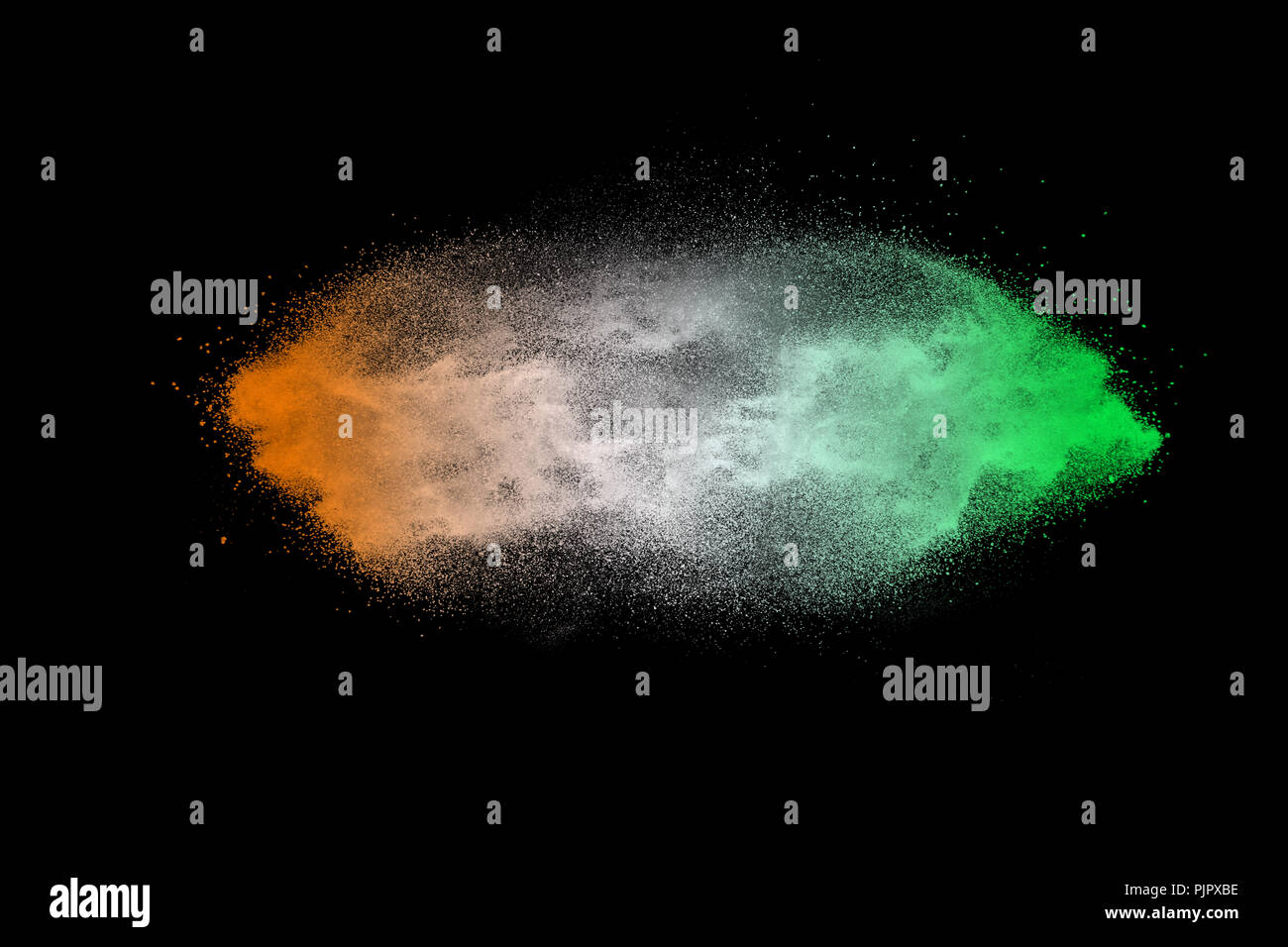 Green orange dust particles explosion on black background. Color powder ...