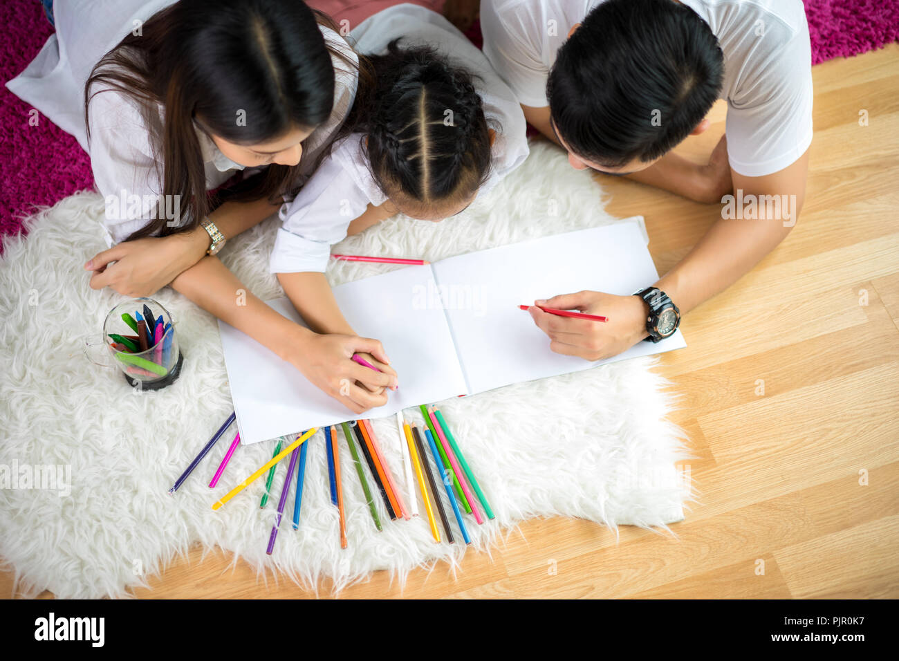 Young family drawing together with colorful pencils at home, kids and ...